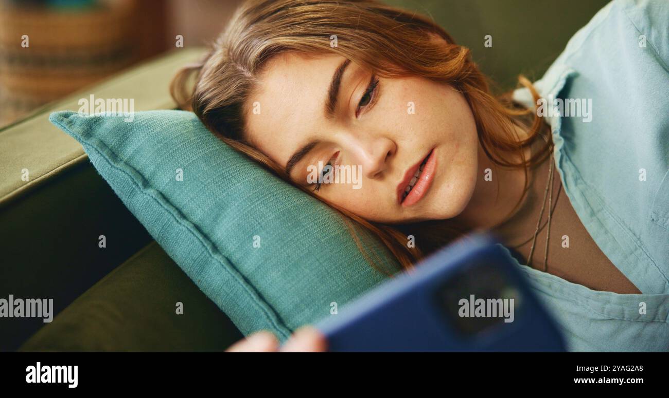 Tired, woman and relax with phone on couch for communication, social ...