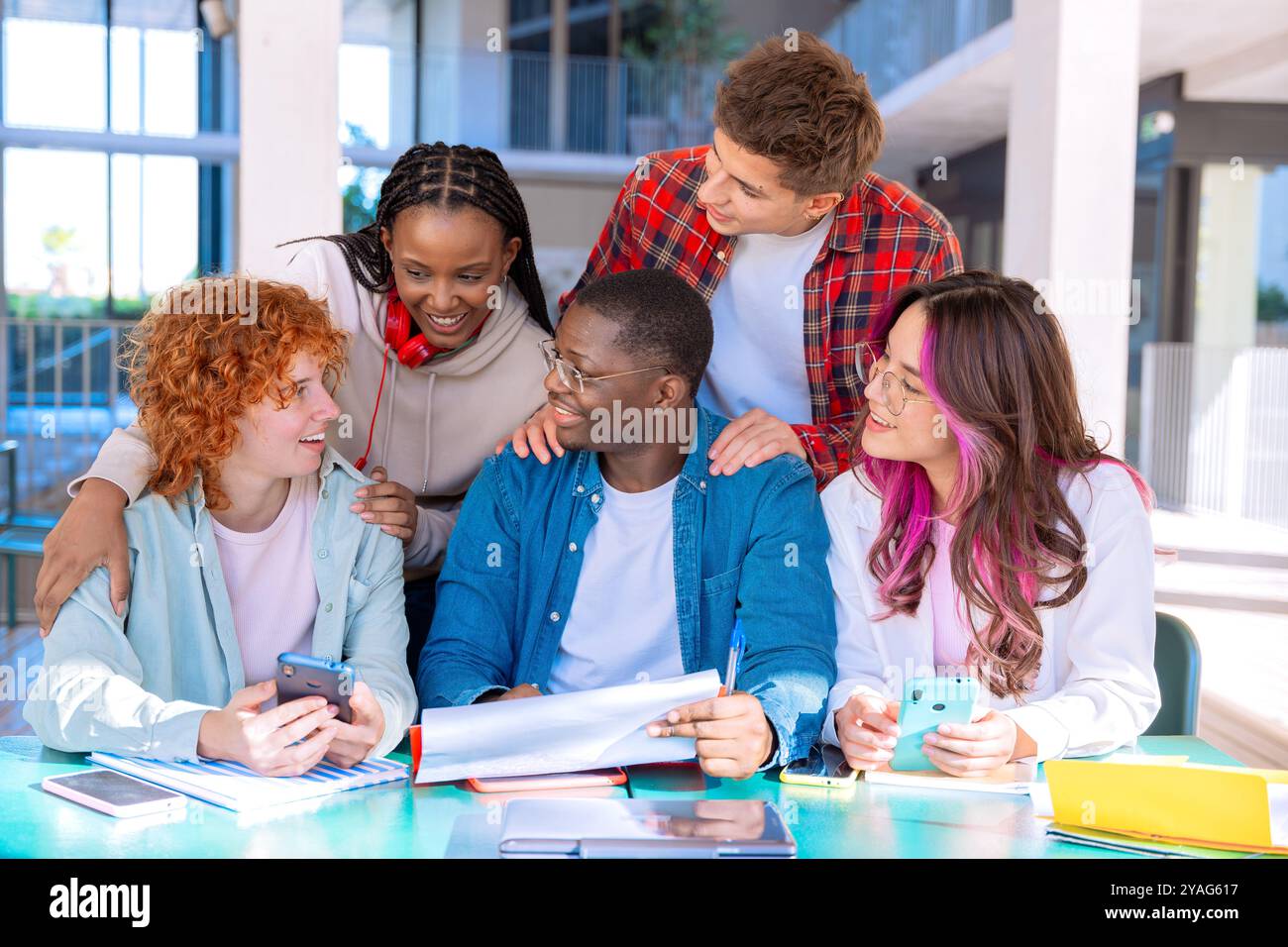 Happy diverse group of students studying in the library Stock Photo - Alamy