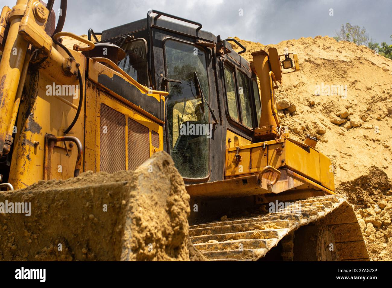 A bulldozer worker is building a water supply system on a tropical ...