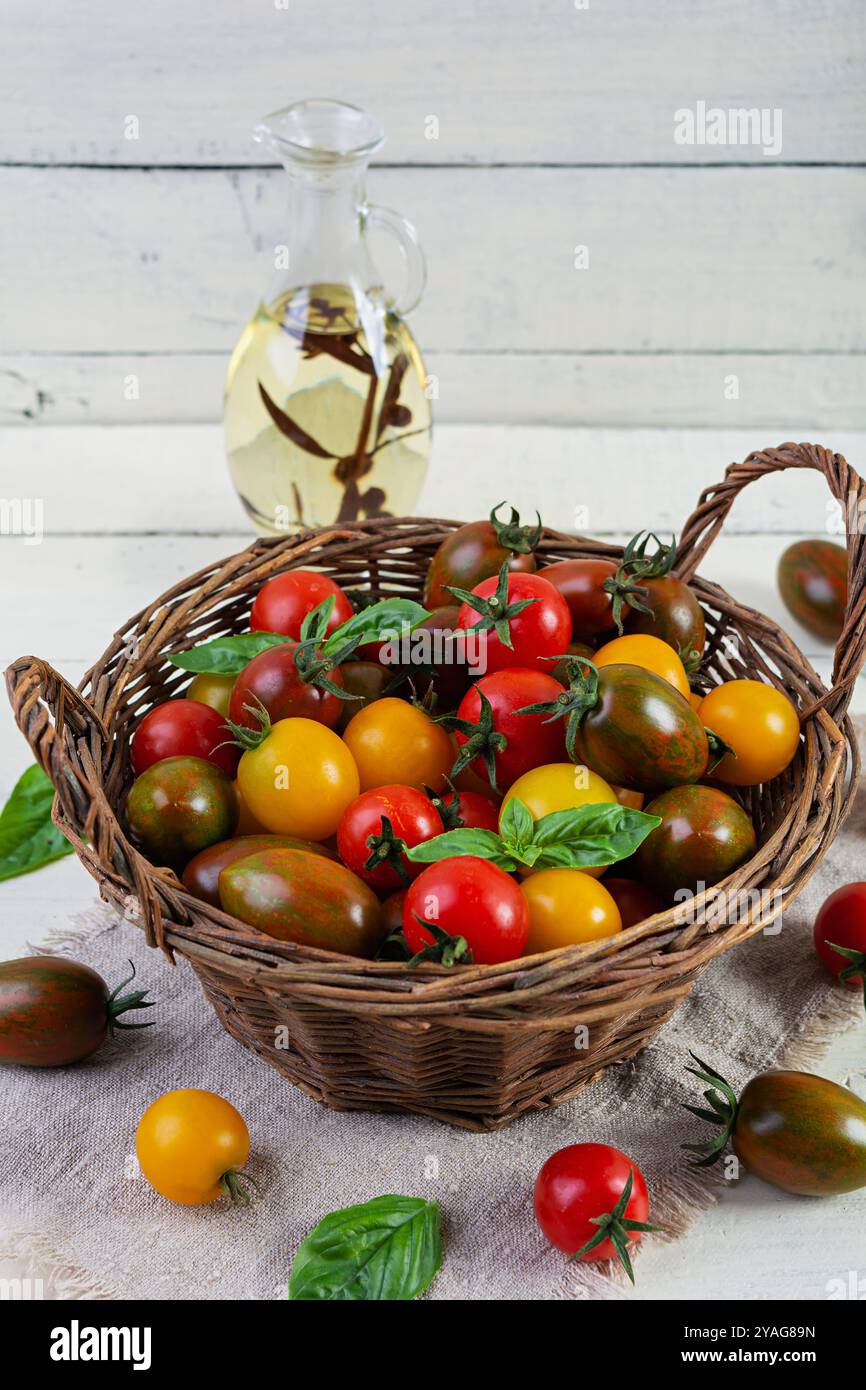 Multi-colored tomatoes in wickerwork basket. Different types of fresh ...