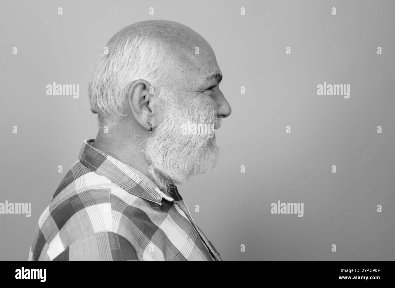 Profile of old mature senior man with grey beard on black studio background. Older grandfather ...