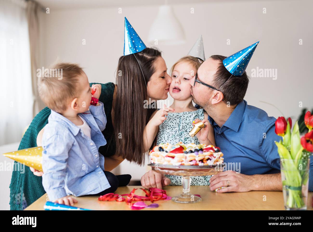 Birthday party with birthday cake. Parents and two kids having surprise ...
