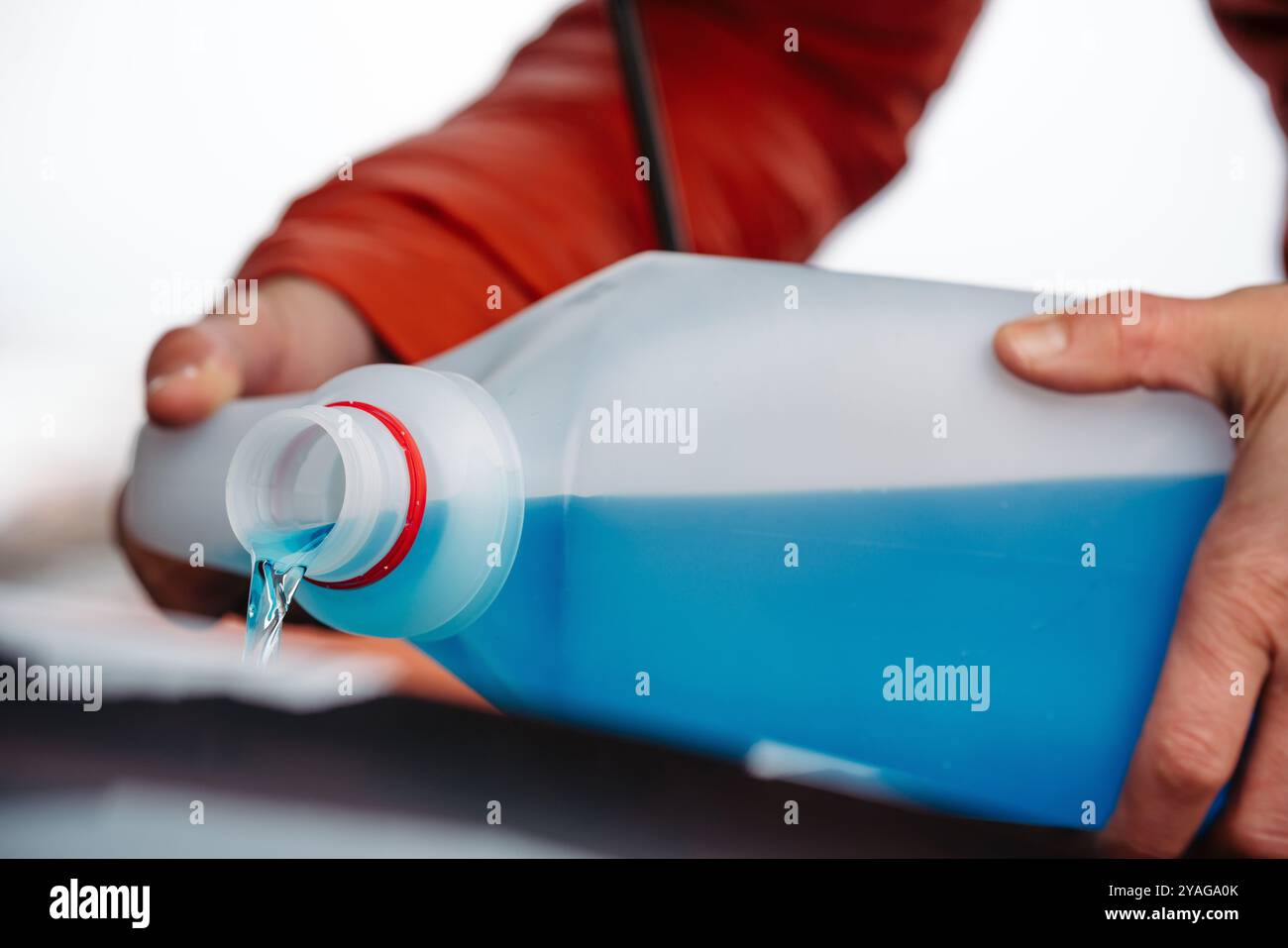 Pouring winter washer fluid into car reservoir during winter ...