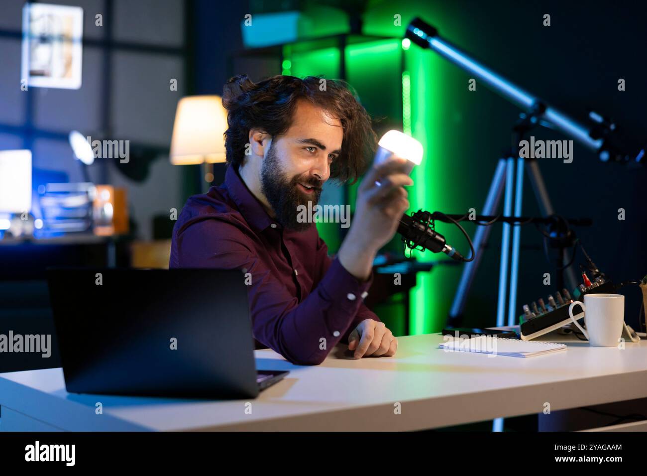 Entertainer with rumpled hair using light bulb to create atmospheric ...
