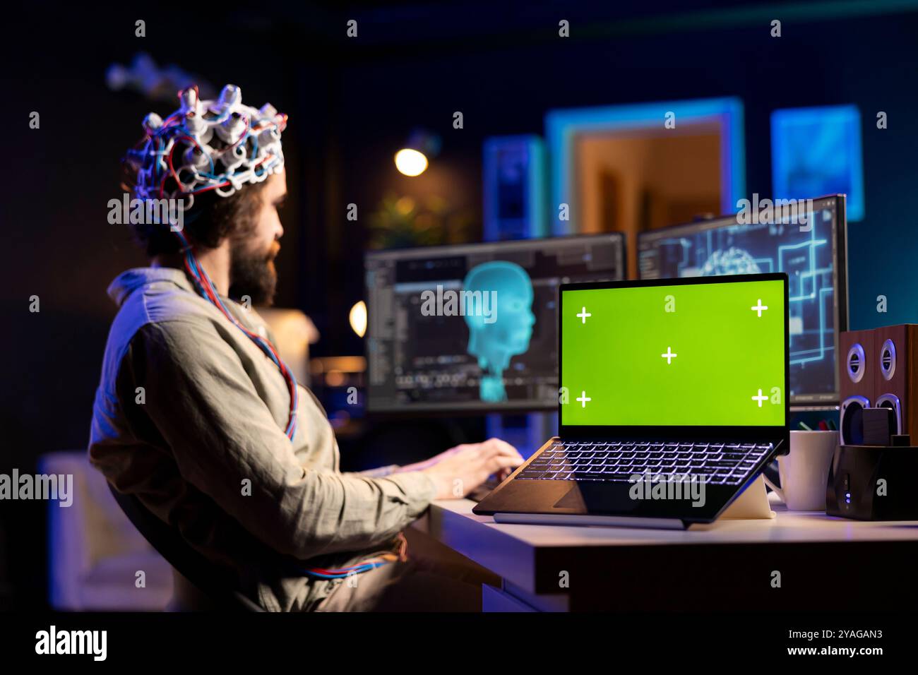 Focus on green screen laptop with man in blurry background using EEG ...