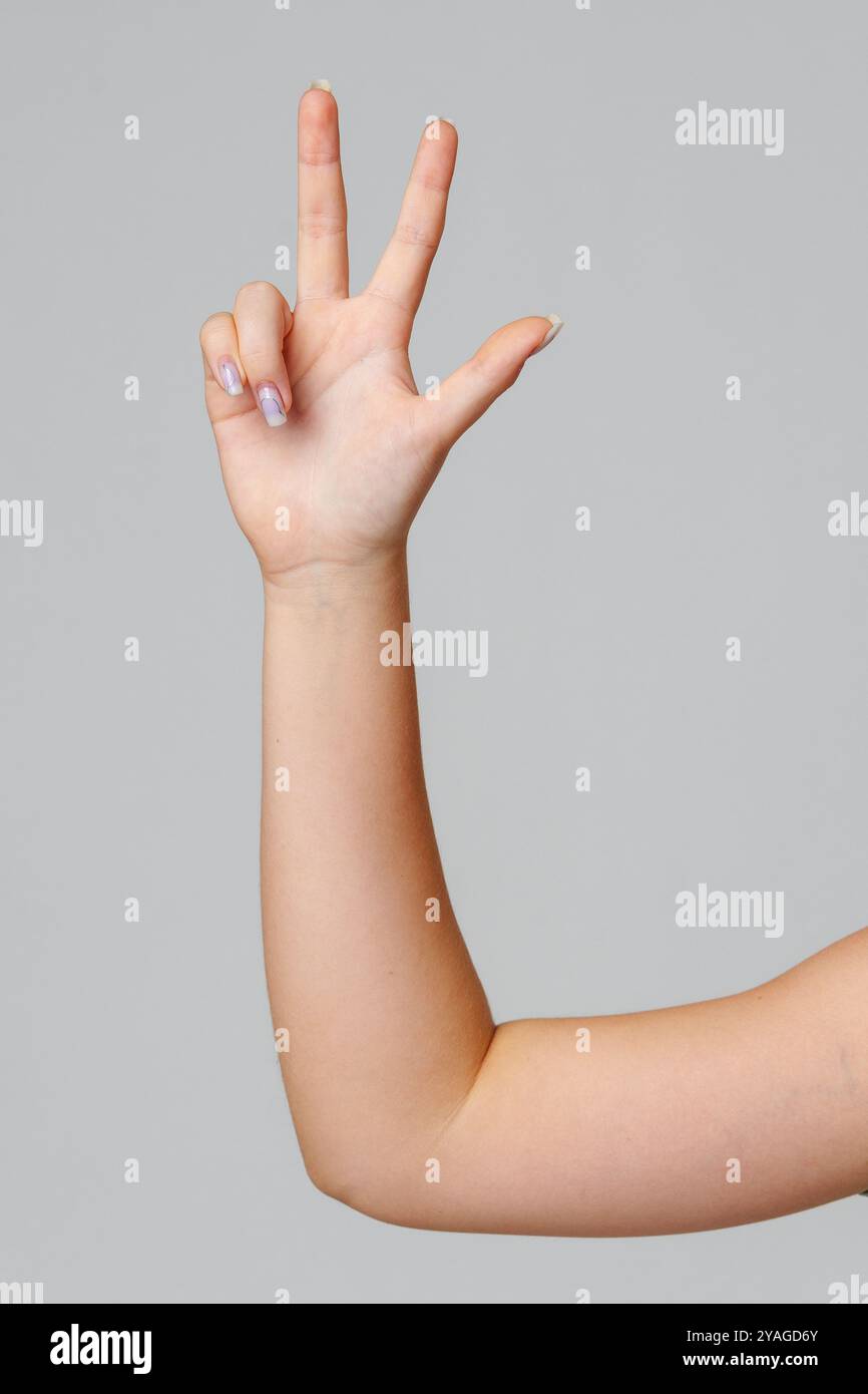 Hand gesture expressing love or appreciation in a neutral setting with ...