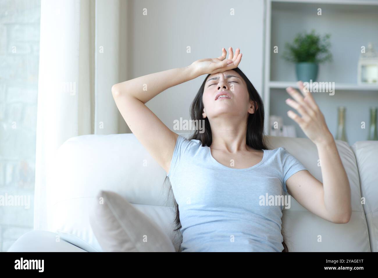 Stressed asian woman suffering heat stroke fanning with hand sitting in ...