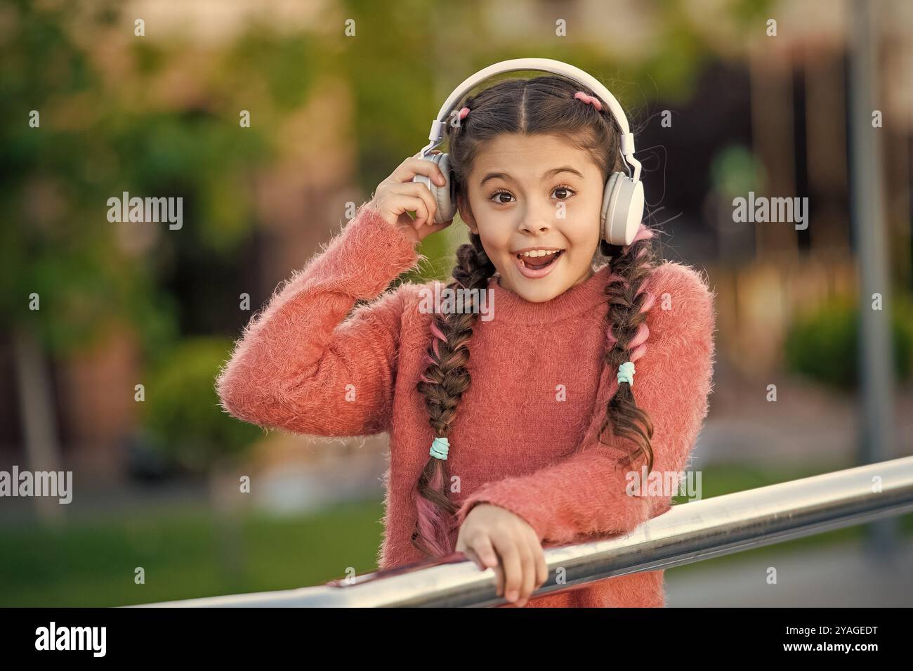 Shocked girl taking off headphones for music. Teenager holding ...
