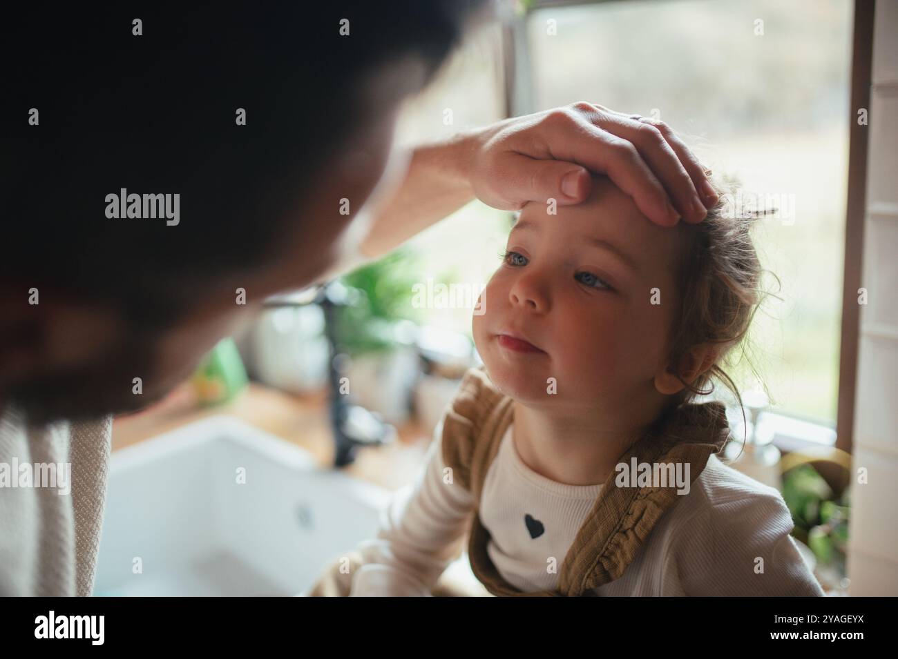 Sick girl with fever and cold at home. Father touching little daughter ...