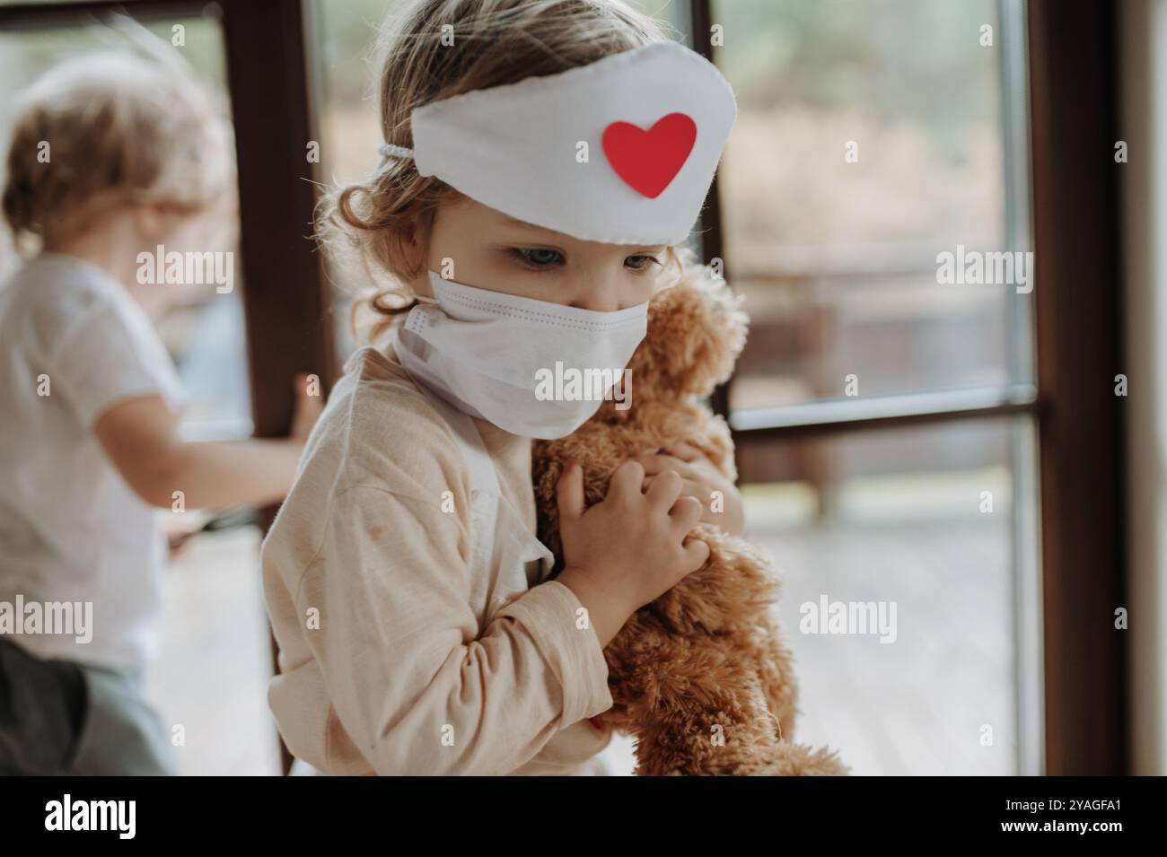 Siblings in doctor uniforms are playing hospital. Little girl as nurse ...