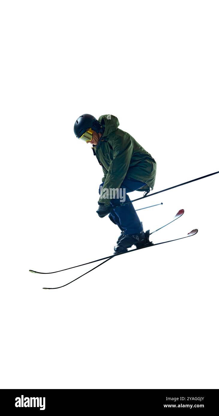 With skis crossed, skier reaches peak of jump, showing off advanced ...
