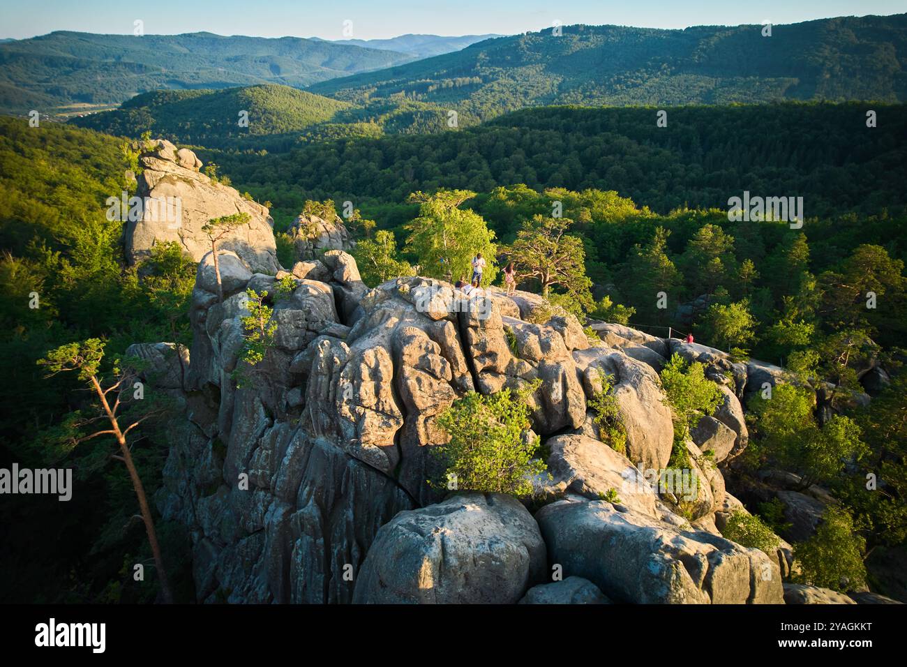 Aerial view of prominent rock formation amidst dense forest. Rolling ...