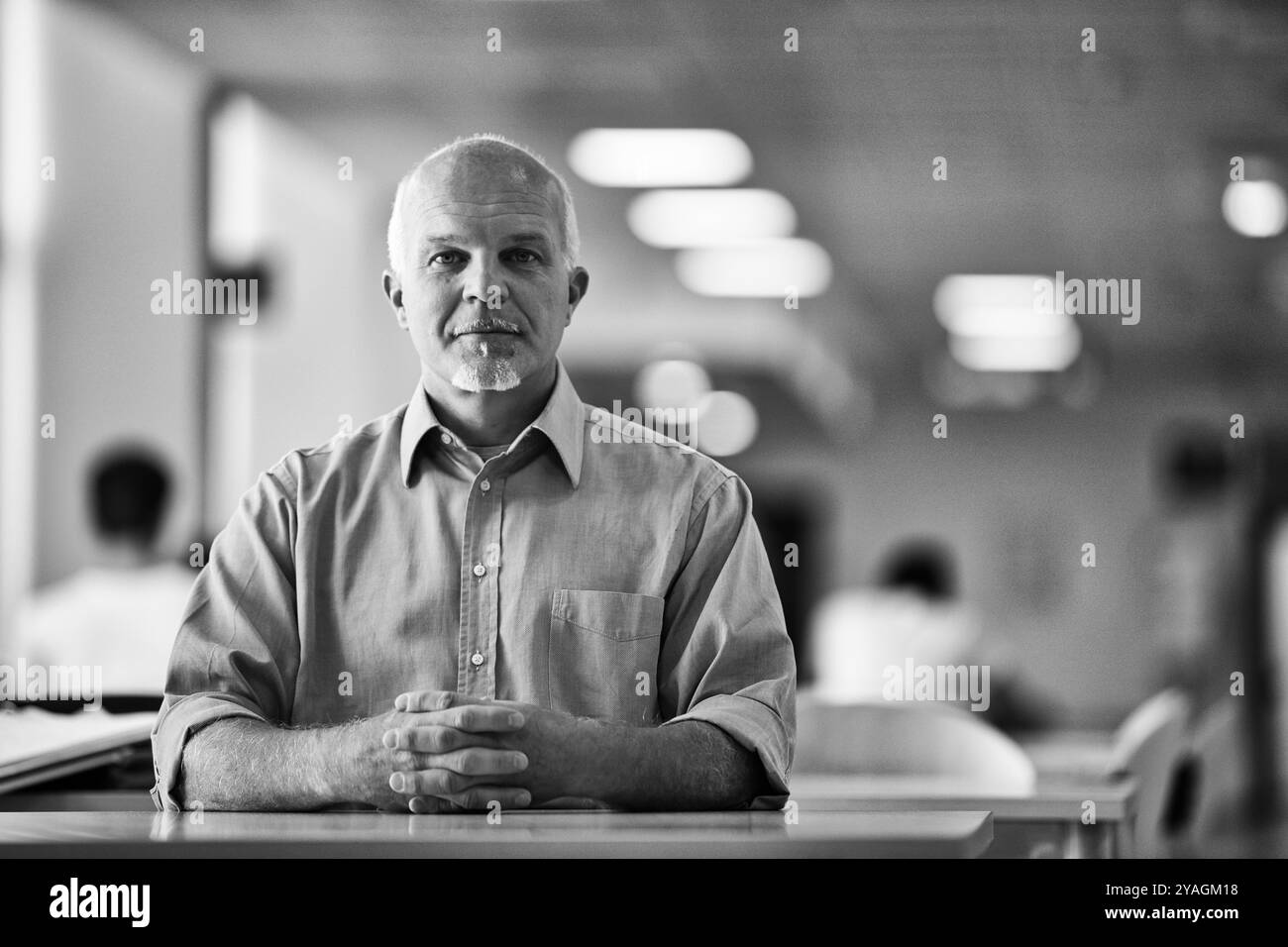 Focused man sits desk in Black and White Stock Photos & Images - Alamy