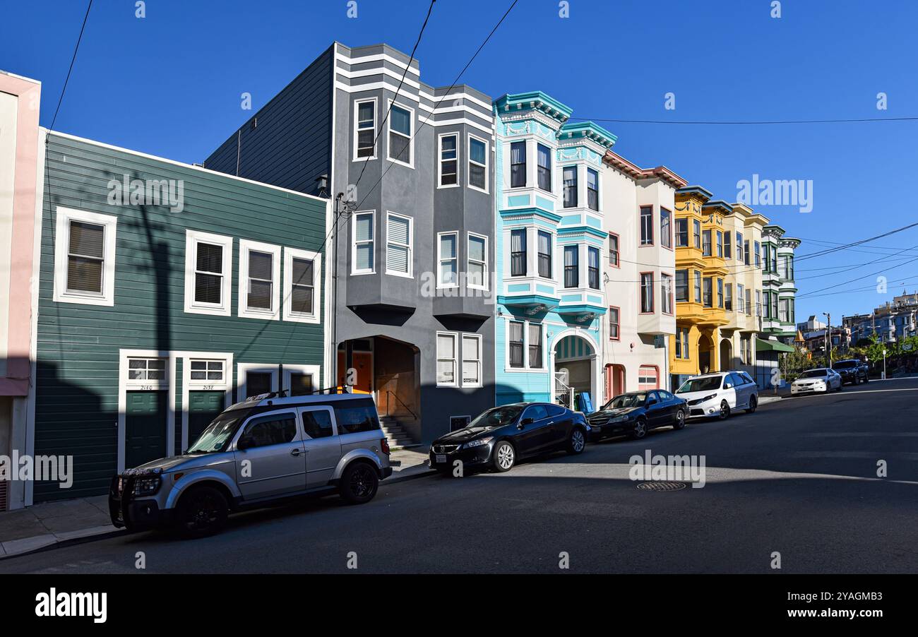 Cars parked in a typical sloping street of San Francisco. Colorful ...