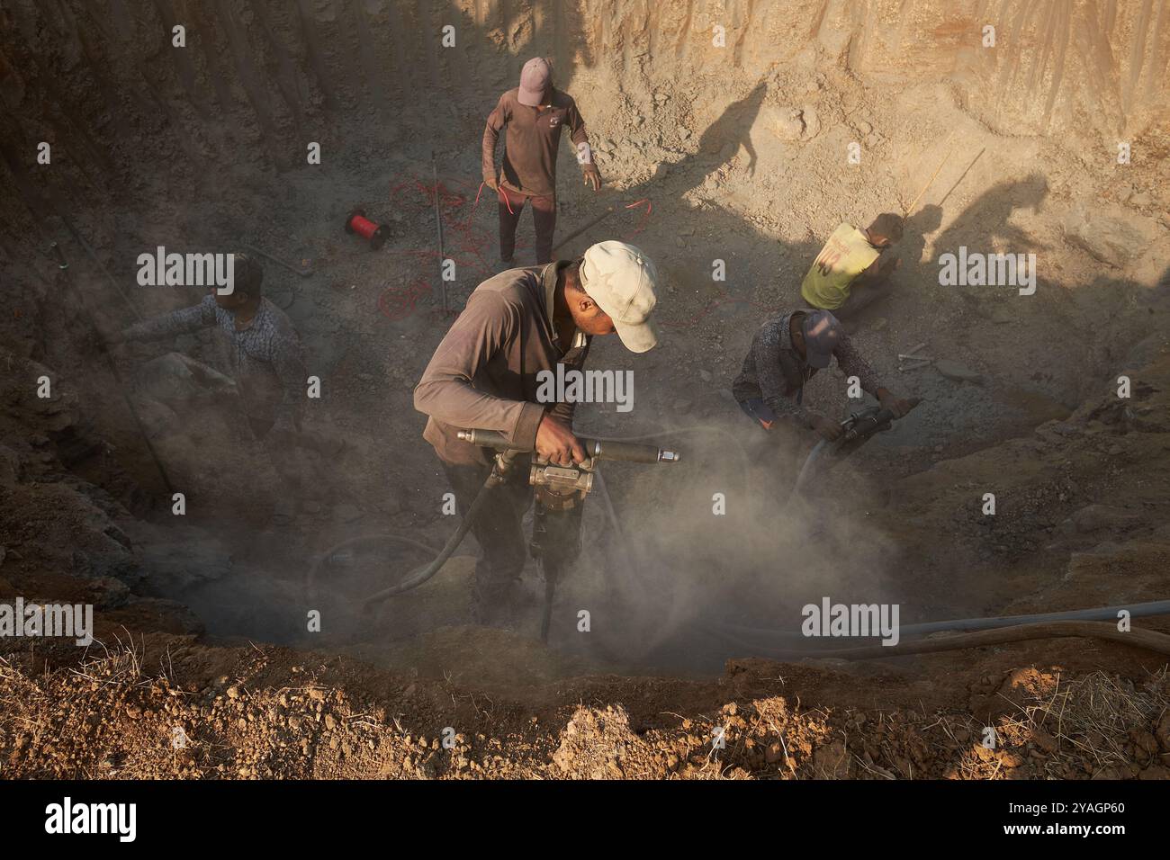 Well diggers use pneumatic drills to make holes in stones where they ...