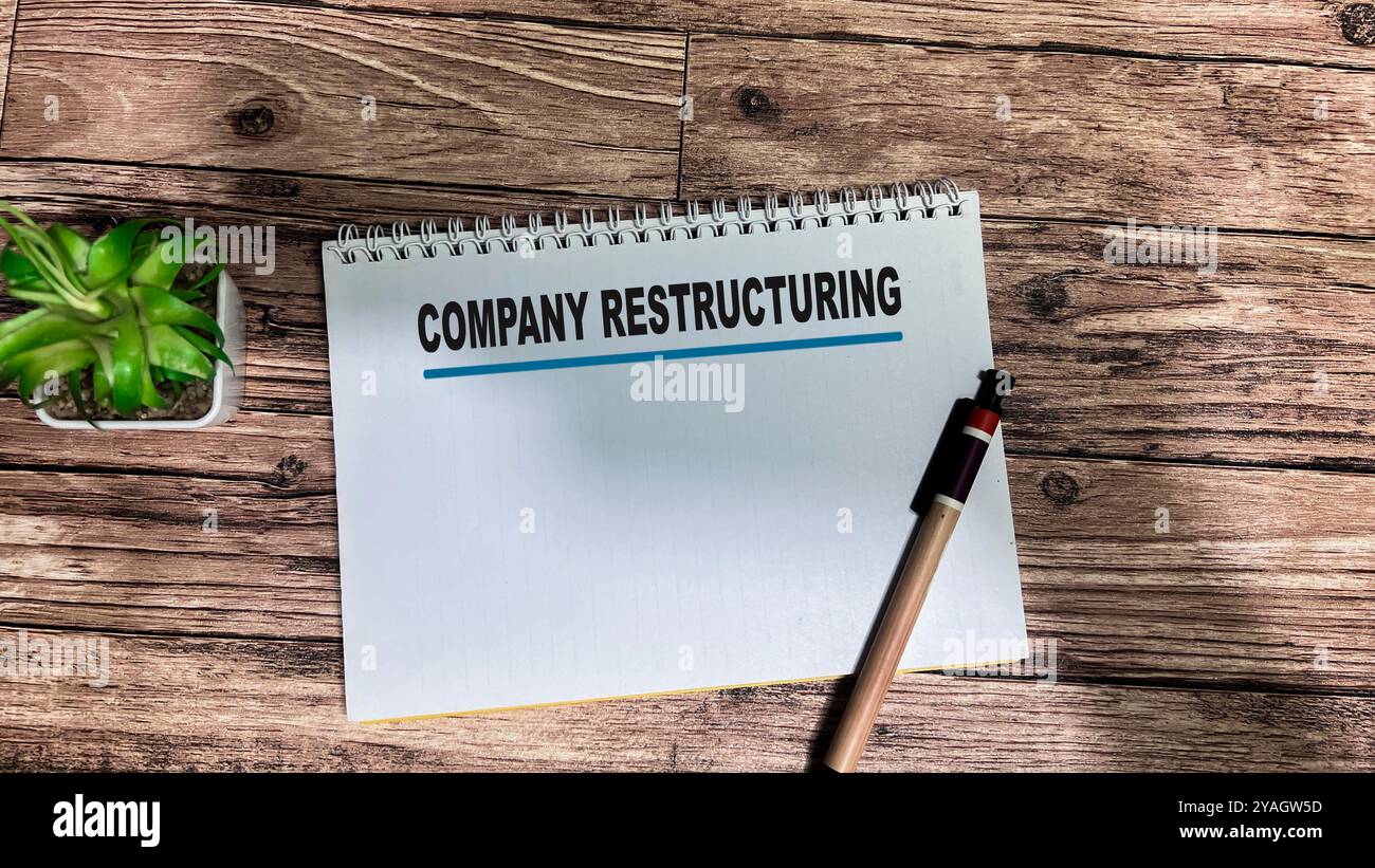 Concept of Company Restructuring write on book isolated on Wooden Table ...