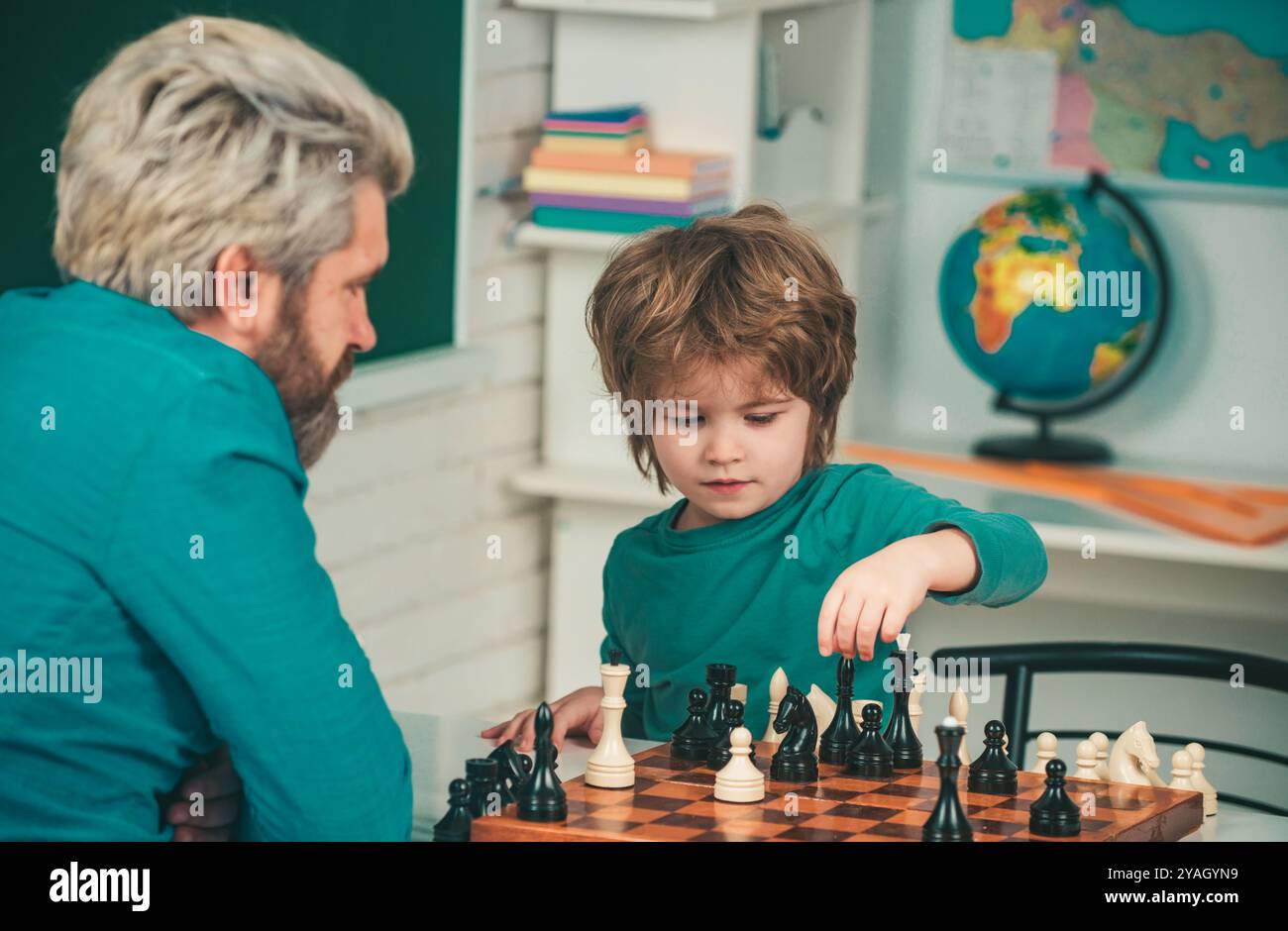 Concentrated boy developing chess strategy. Cute boy developing chess ...
