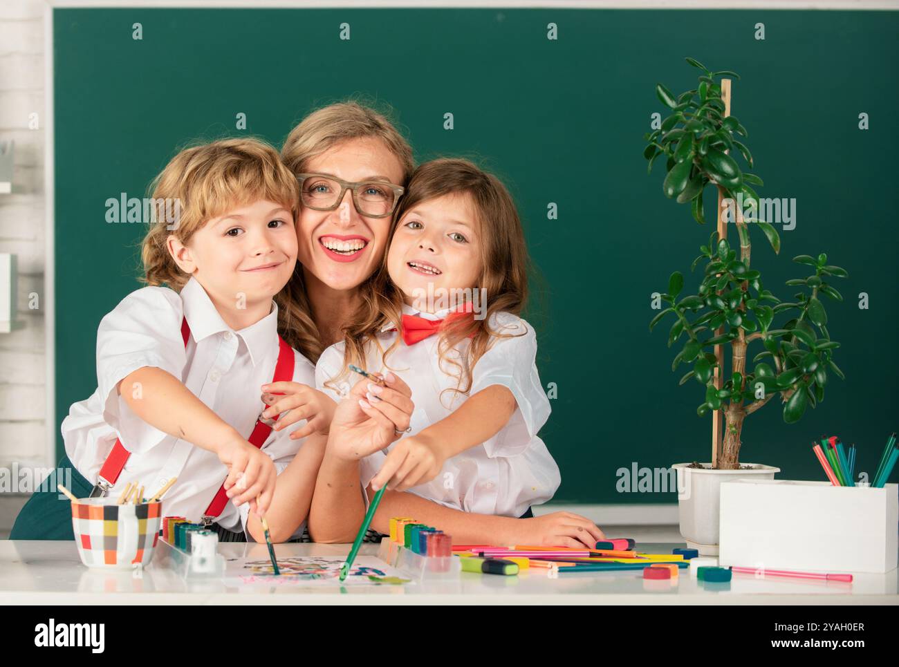 Back to school. School kids drawing with teacher. Children from ...