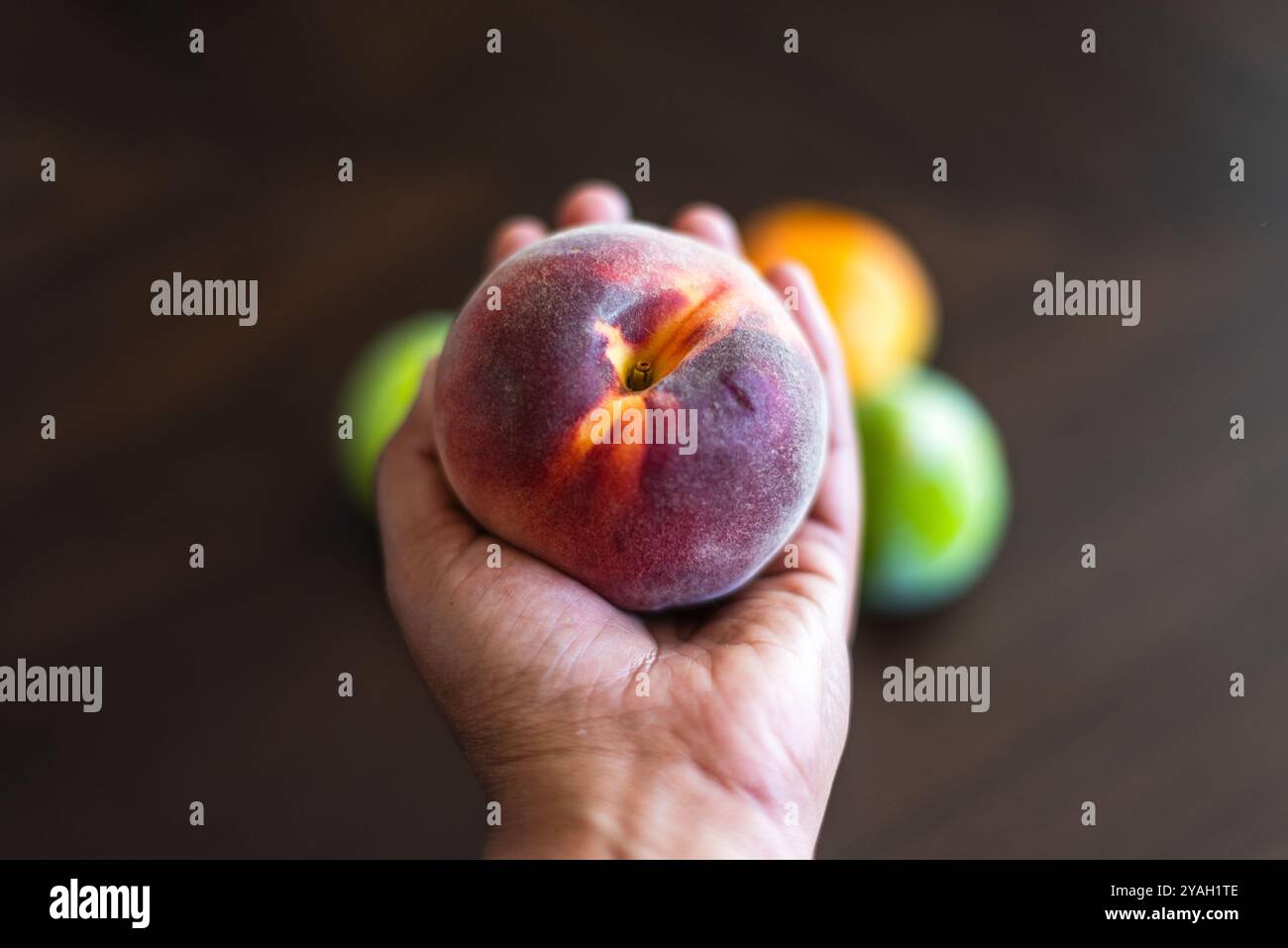 Hand holding fresh peach hi-res stock photography and images - Alamy