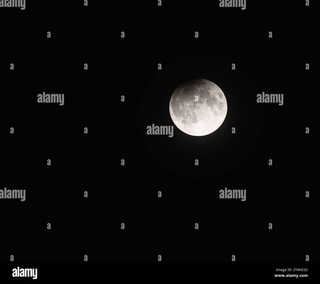 Partial lunar eclipse of full moon against black night sky Stock Photo ...