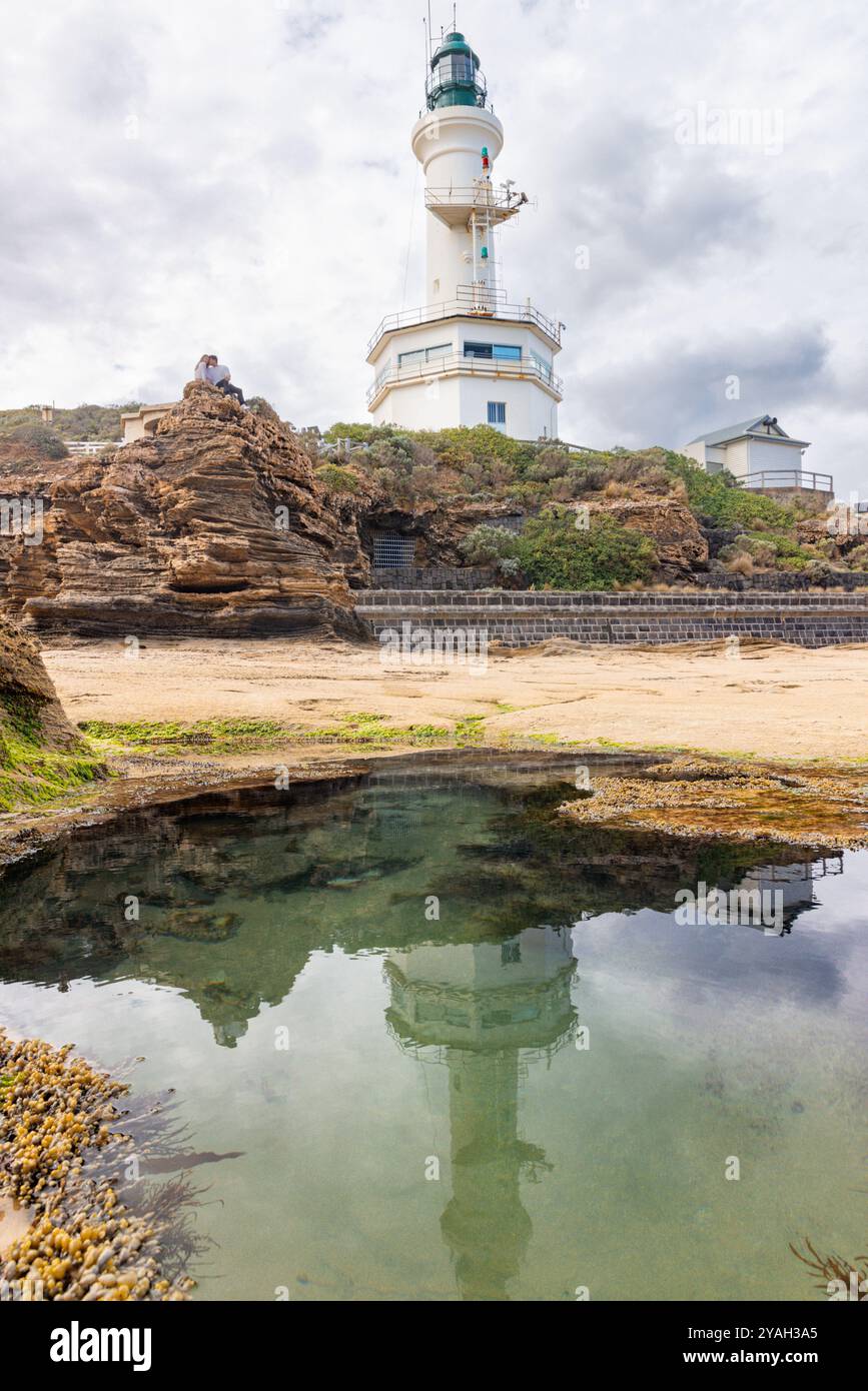 Reflection of Point Lonsdale Lighthouse in rock pool under cloudy sky ...
