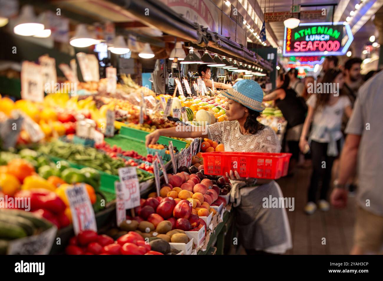 Woman stocking produce at farmers market stand Pike Place Stock Photo ...