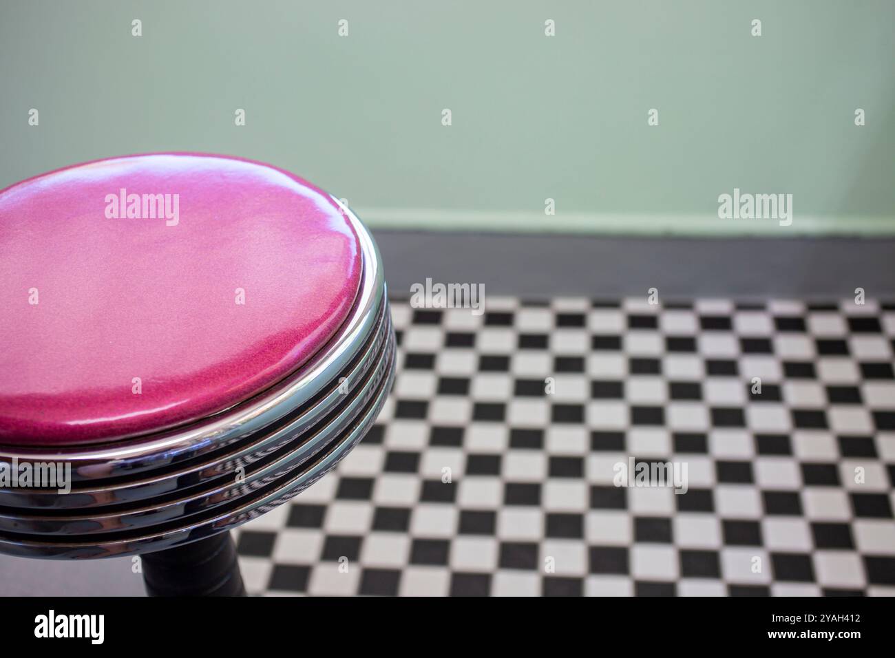 Magenta stool checkered floor in retro diner Stock Photo - Alamy
