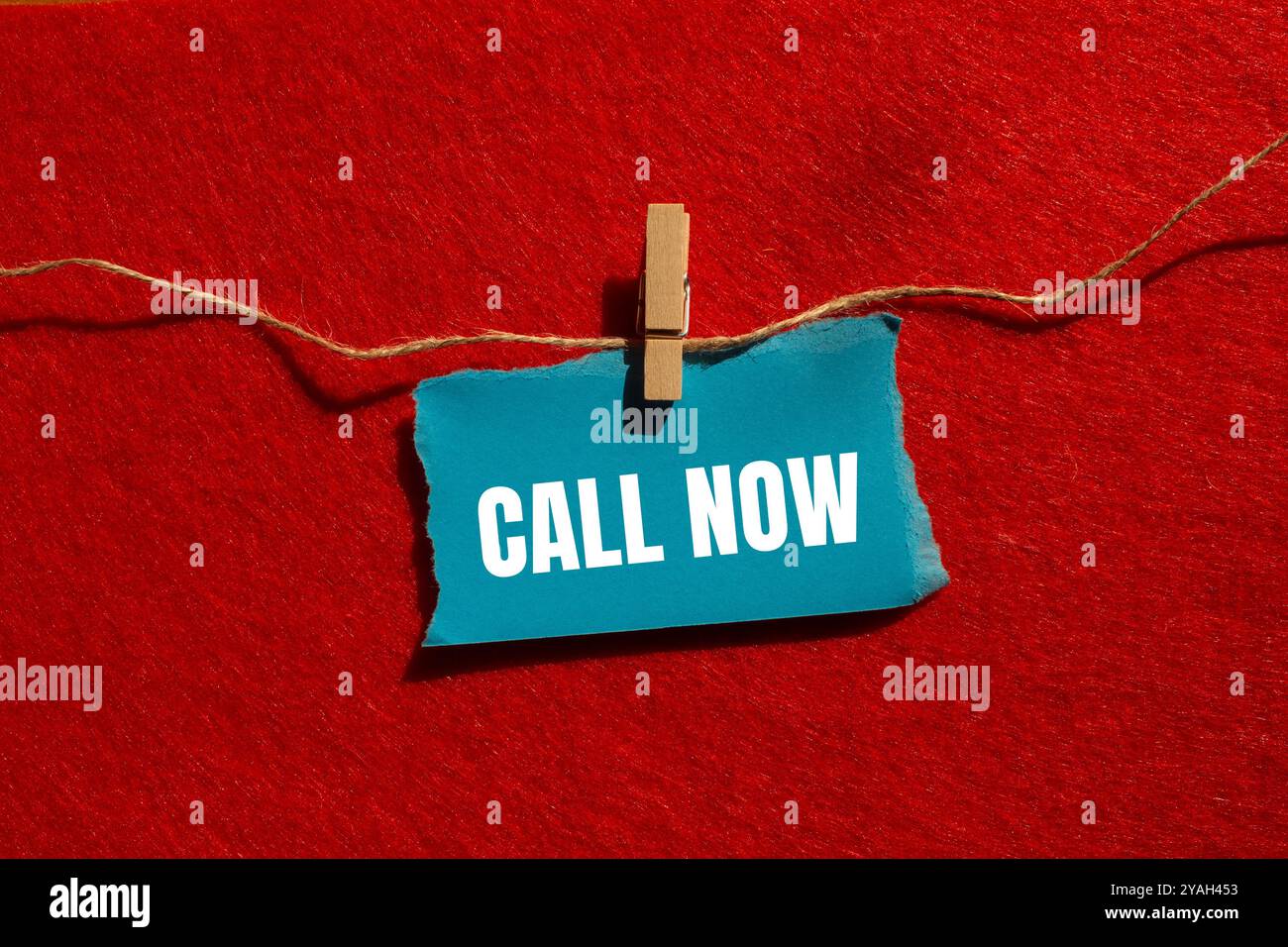 Call now message written on ripped torn blue paper piece with red ...