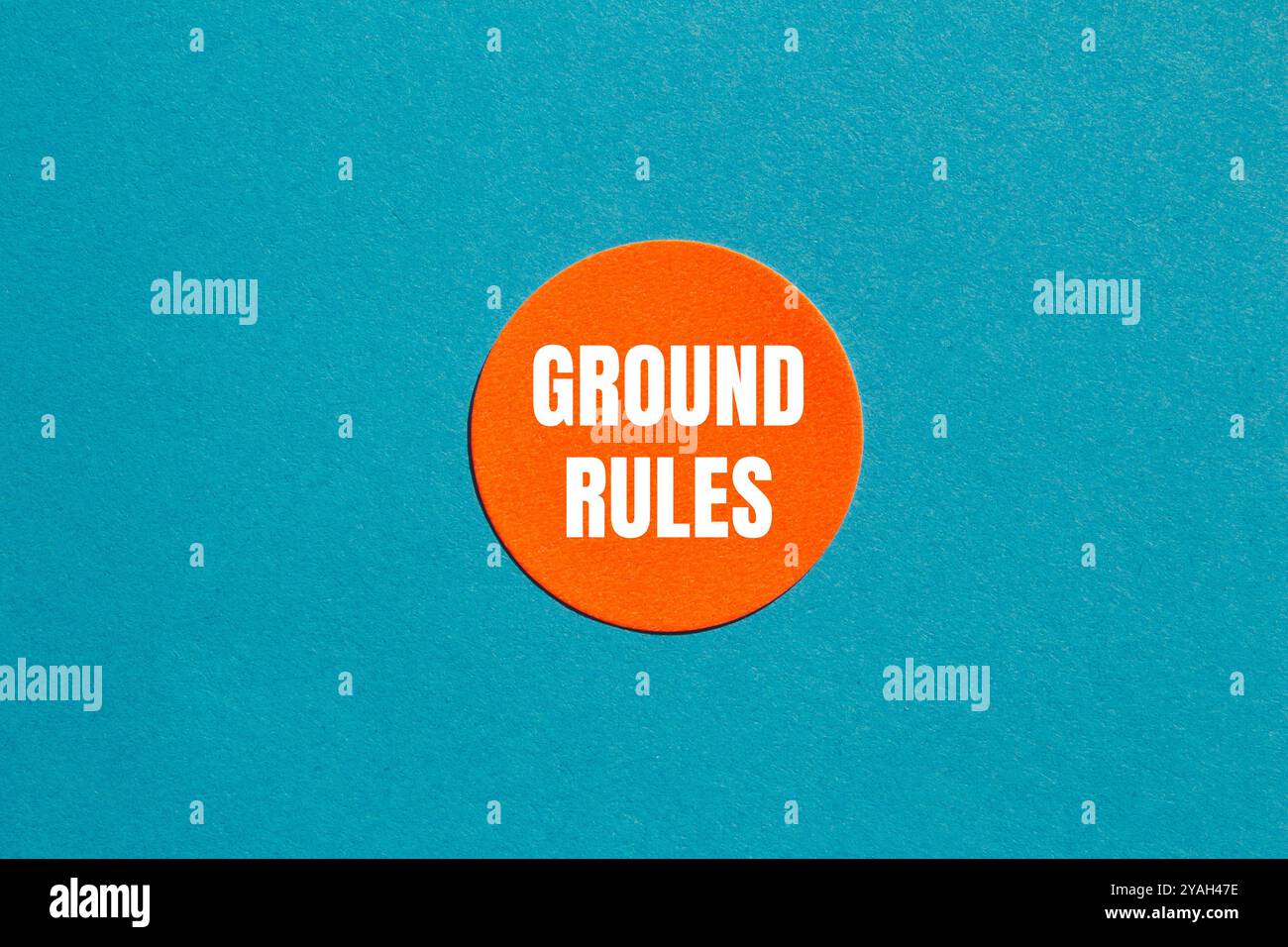 Ground rules message written on round orange sticker with blue ...