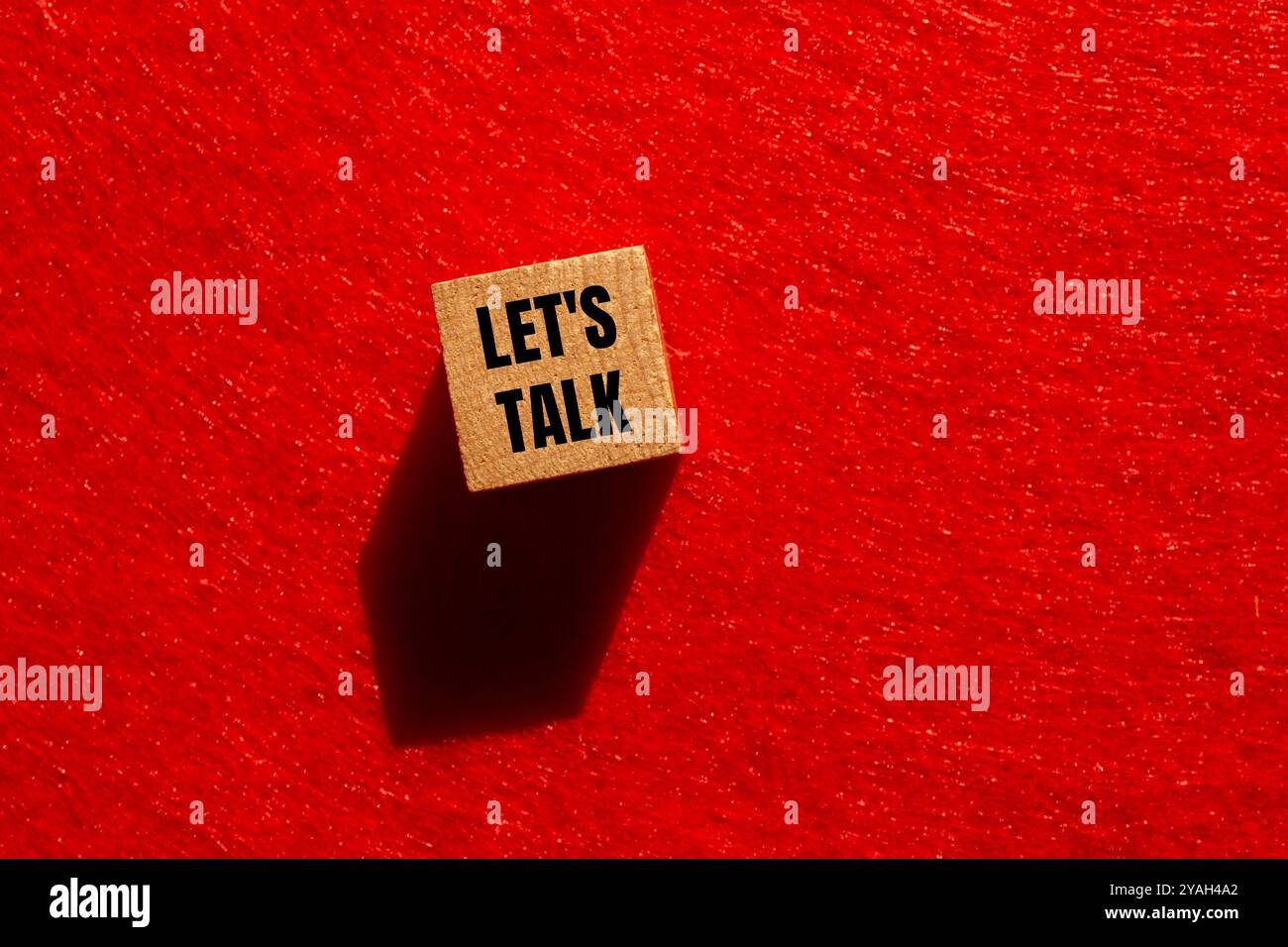 Let's talk message written on wooden cube with red background ...