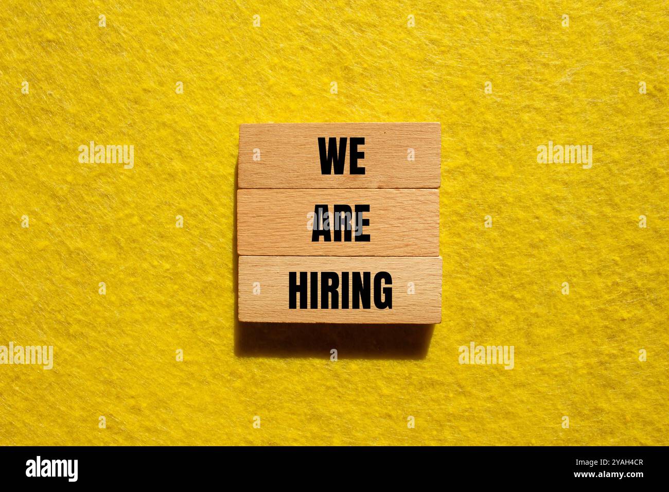 We are hiring message written on wooden blocks with yellow background ...