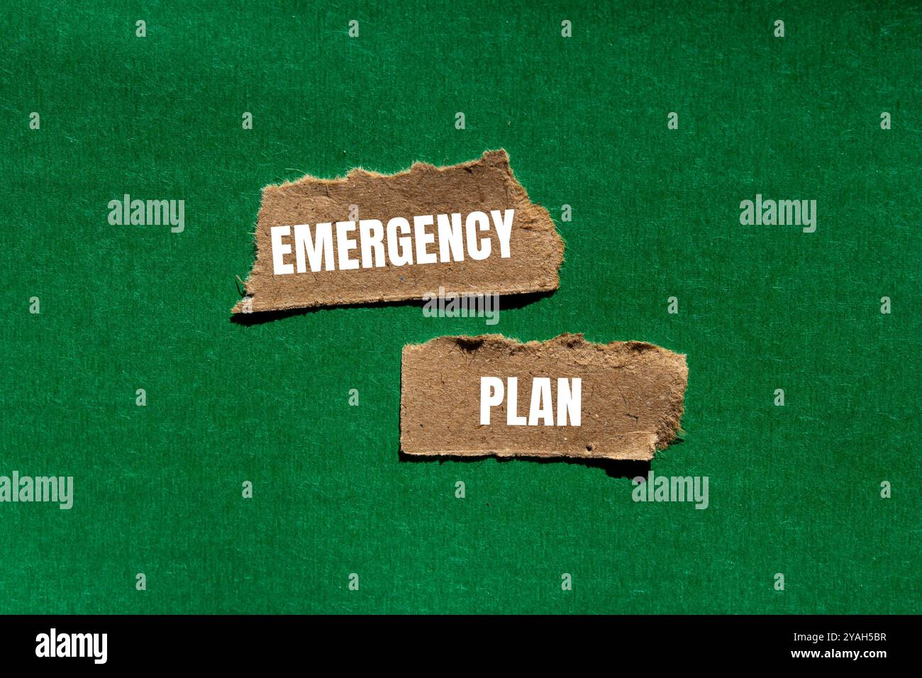 Emergency plan message written on ripped torn paper pieces with green background. Conceptual ...