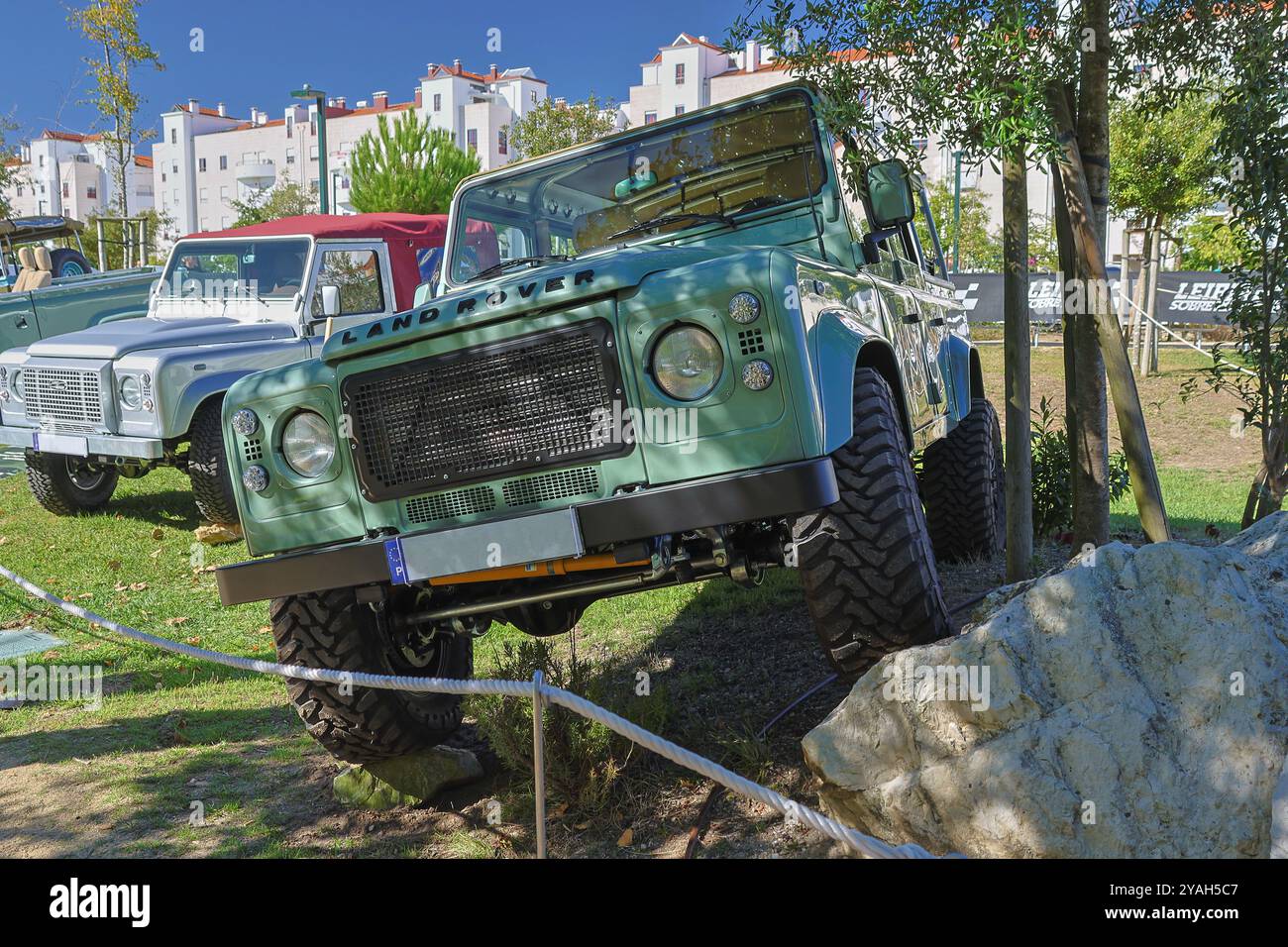 Green land rover defender is exhibiting its off road capabilities by ...