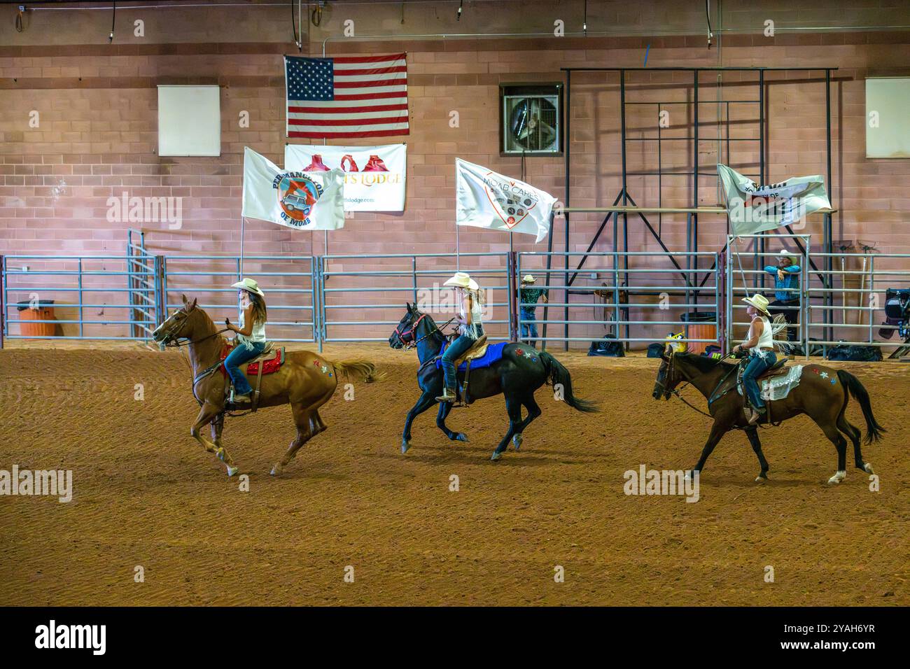 Cowgirls in a mounted drill team perform with flags in the Grand Entry ...