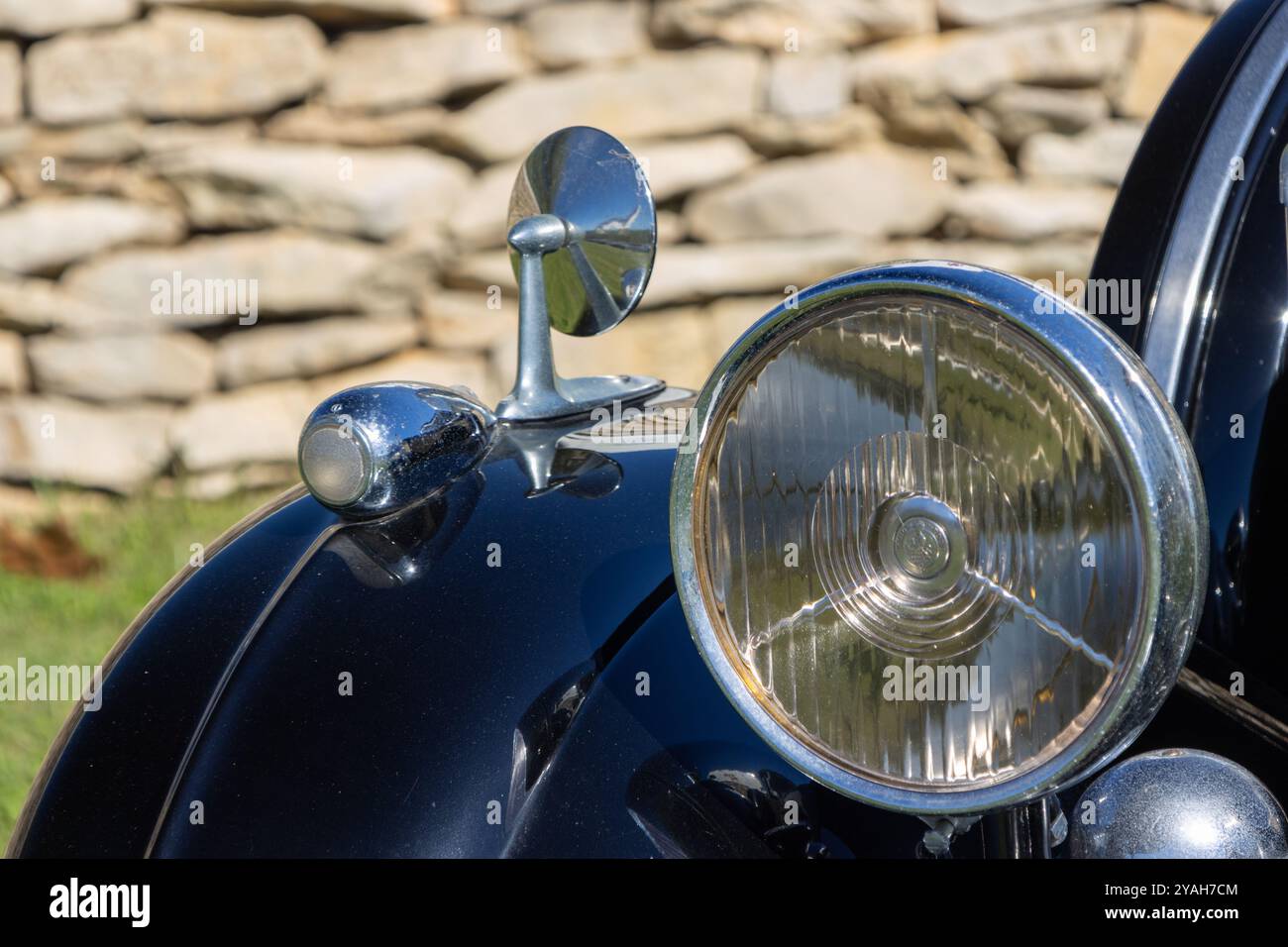 Gleaming chrome headlight and side mirror are featured on a vintage ...