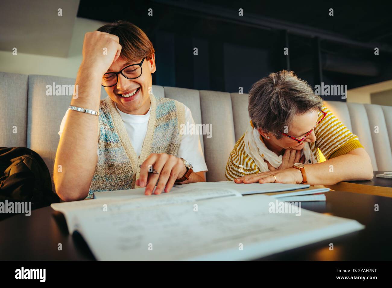 Student and lecturer sharing a laugh during a study session, depicting ...