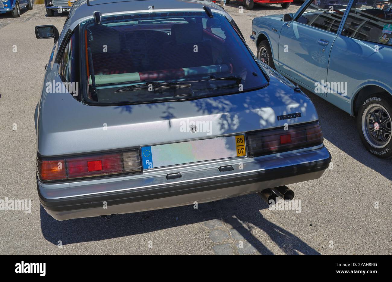 Silver mazda rx 7 is parked on a sunny day, with the shade of a tree ...