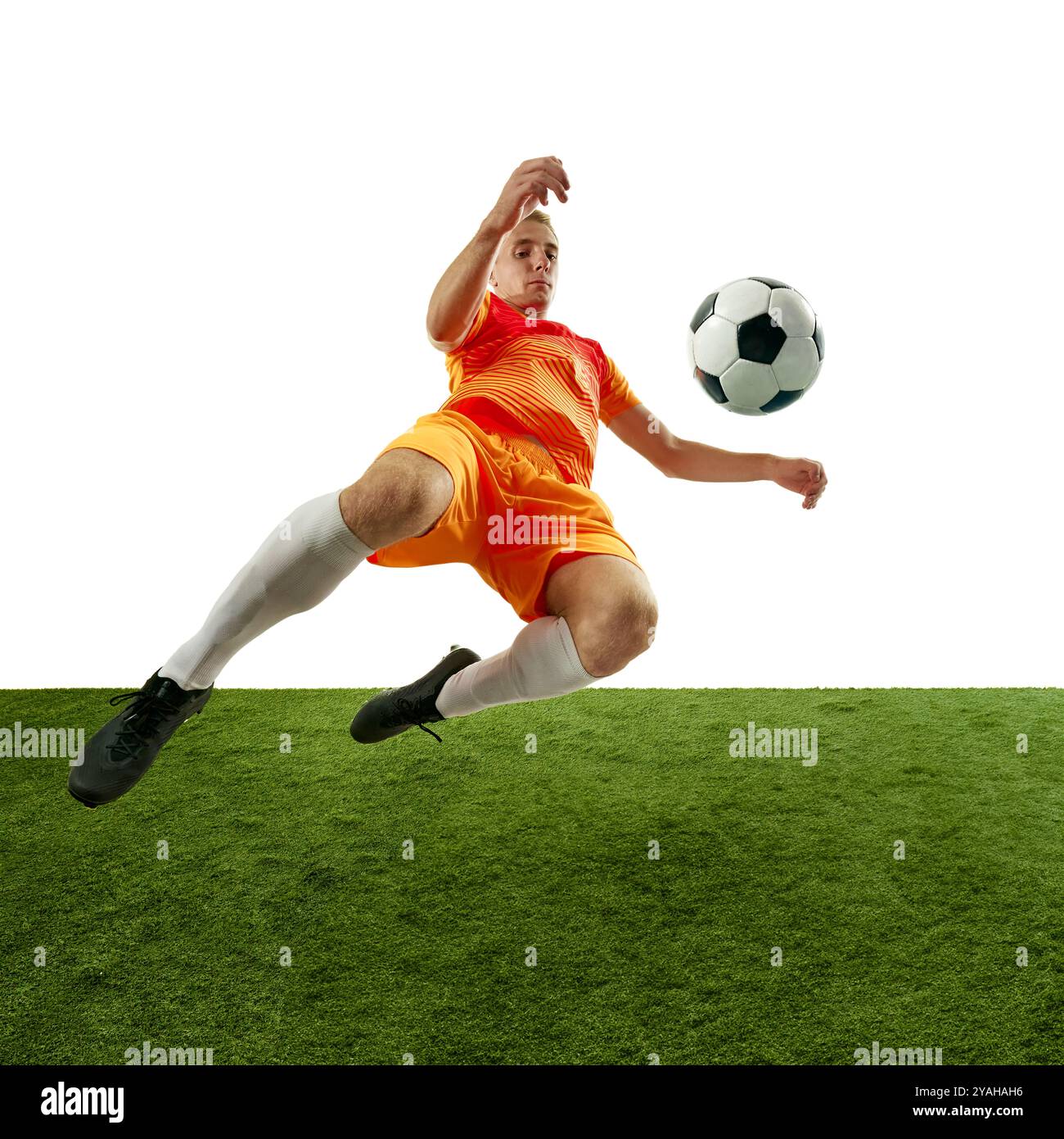 Focused soccer player executing perfect high kick, showing agility and ...