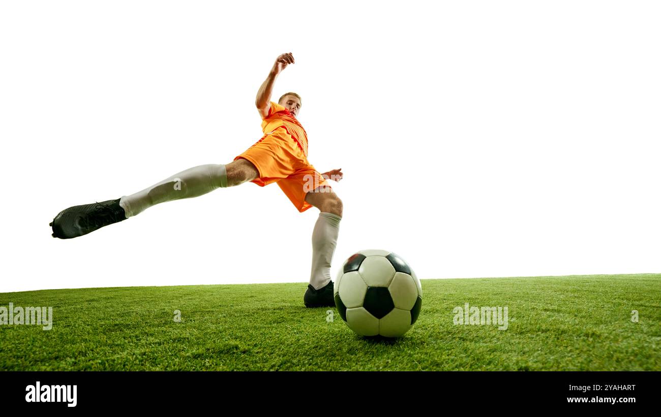 Football player performs powerful kick towards ball, displaying dynamic ...