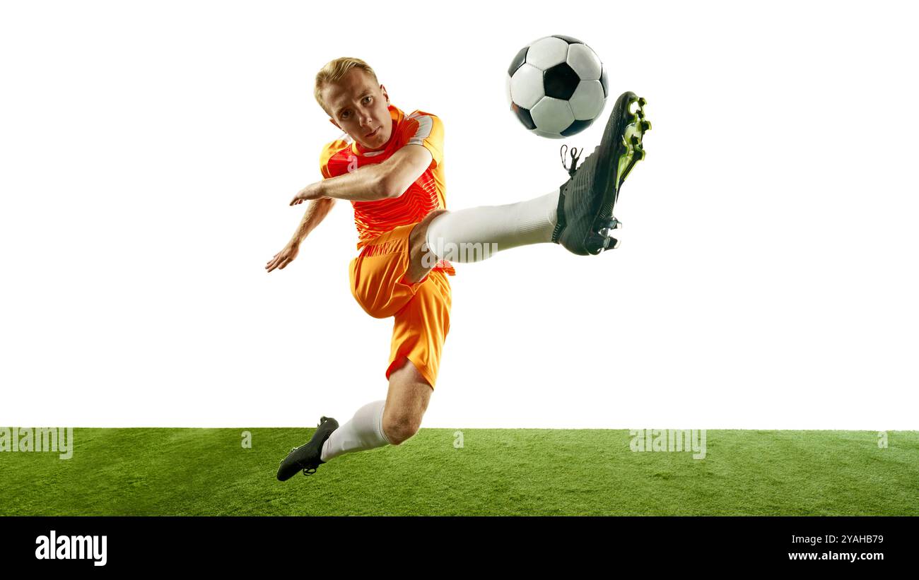 Young male football player in mid-air kick with full focus on ball ...