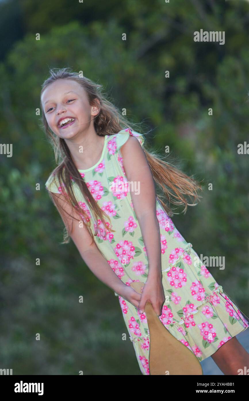 little girl with paddle rocket playing backyard tennis and laughing ...