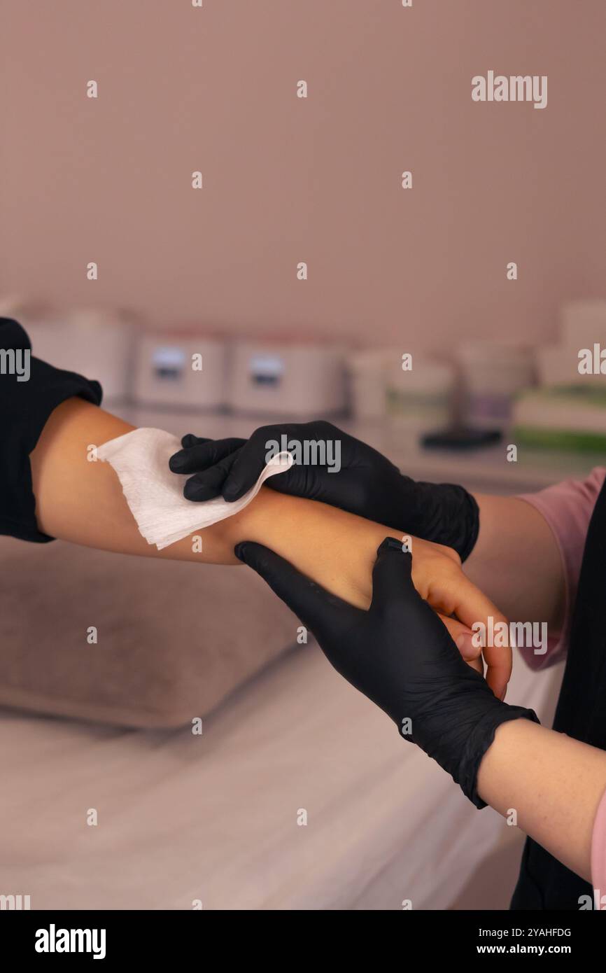 A professional applying a bandage on a clients arm in a clean treatment ...