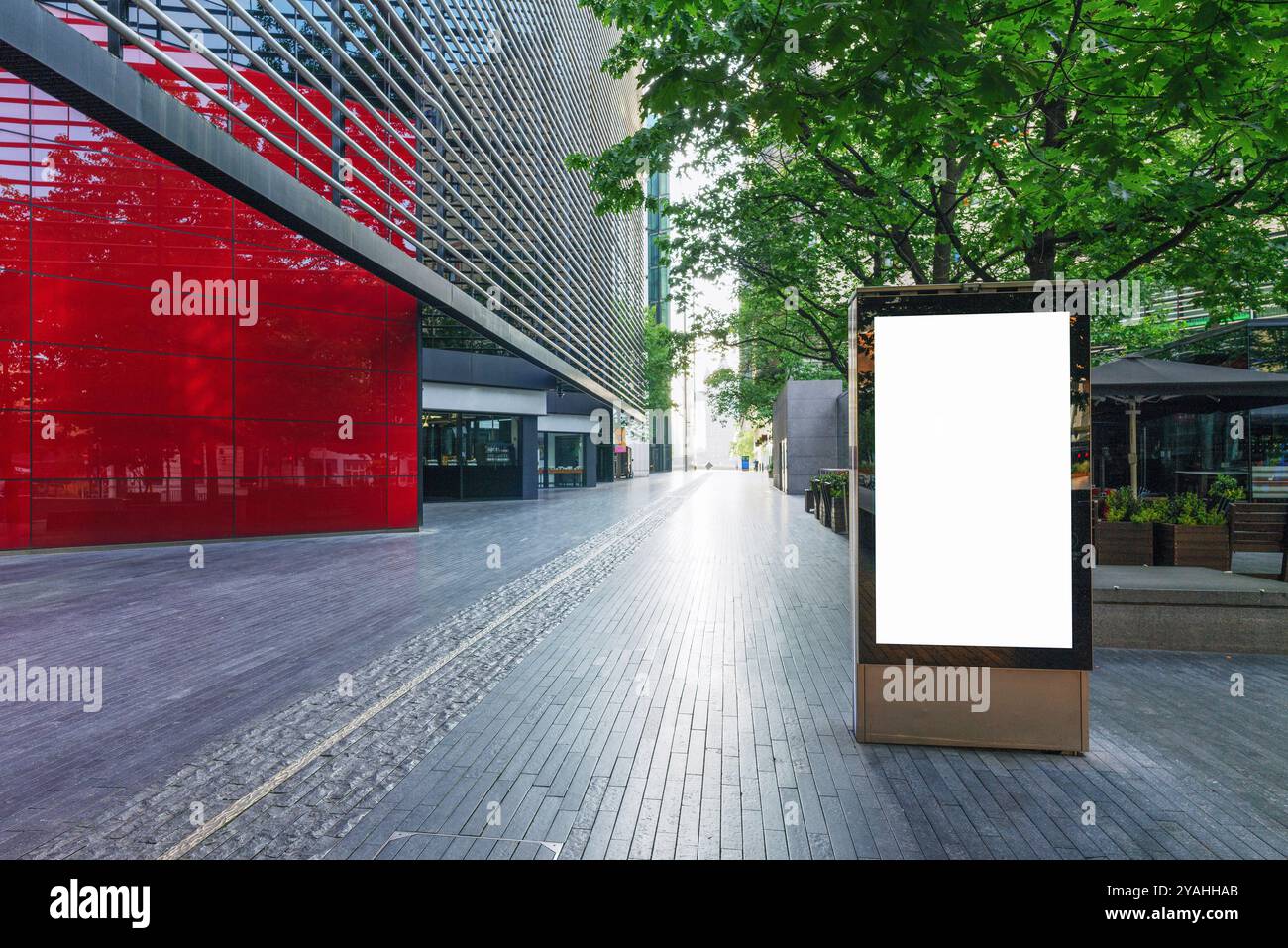 Blank digital billboard at a walkway amidst modern office buildings in ...
