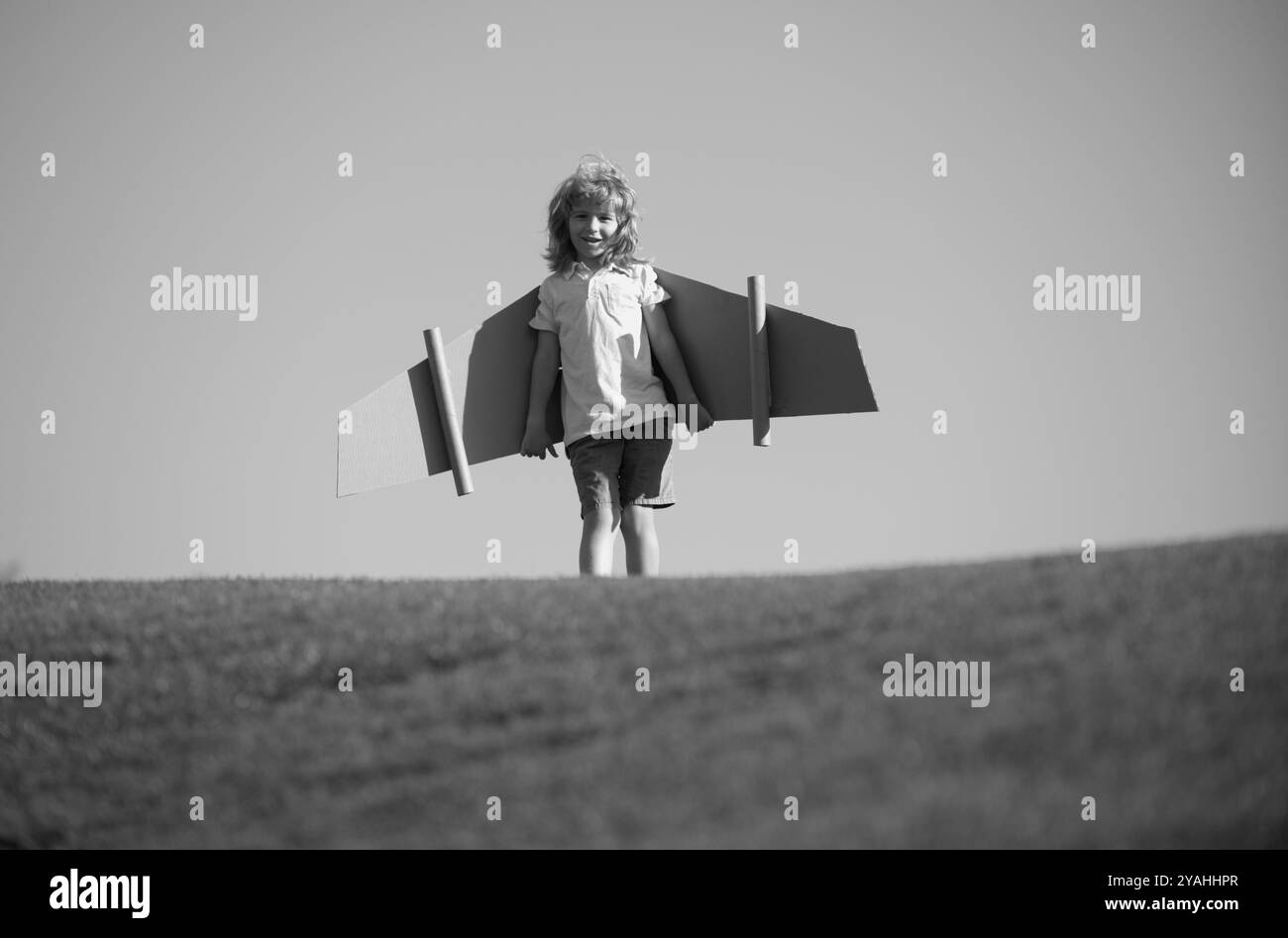 Funny child boy playing with plane wings outdoors. Cute boy playing ...