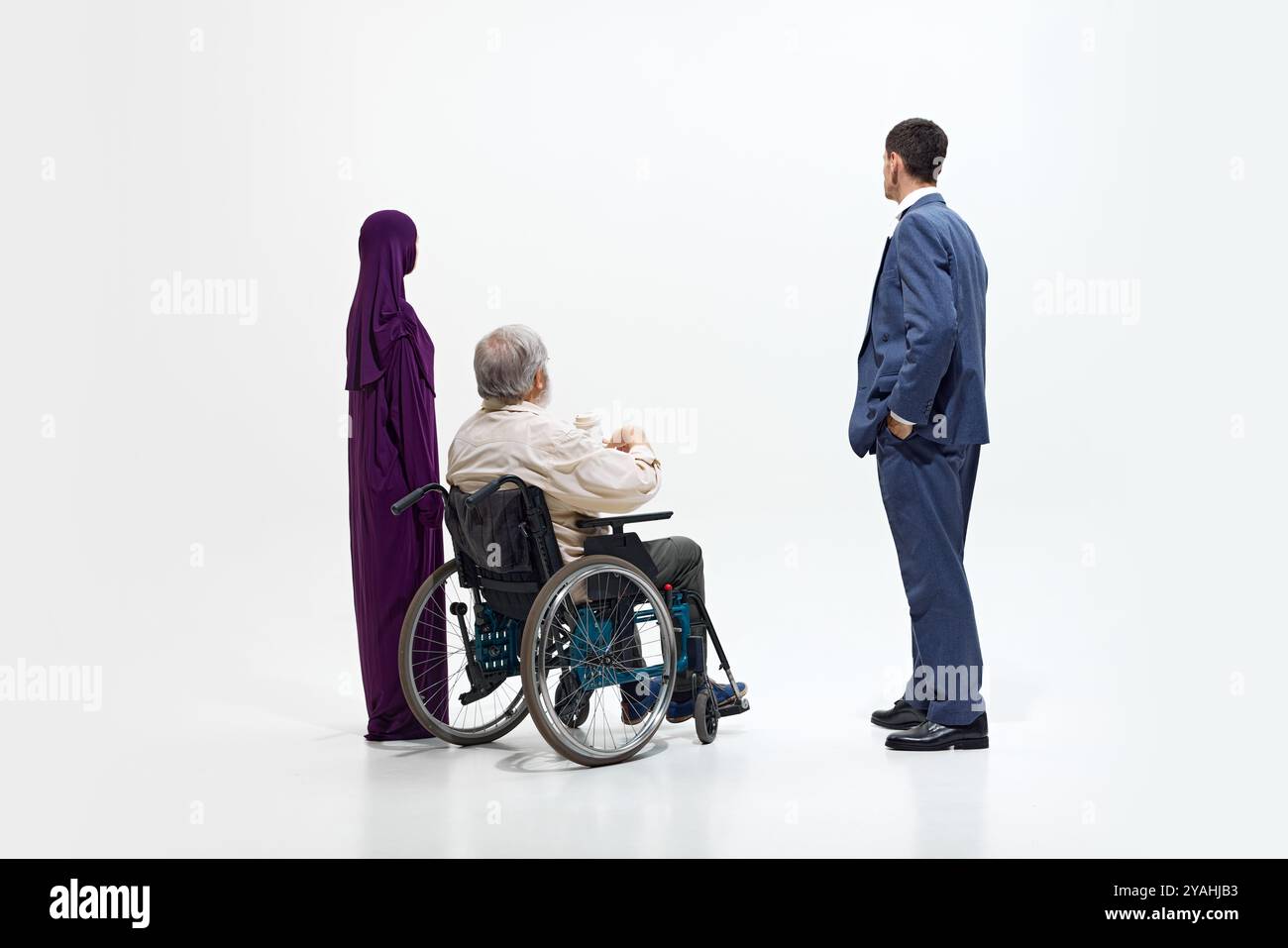 Diverse people, including man in wheelchair, look forward while ...