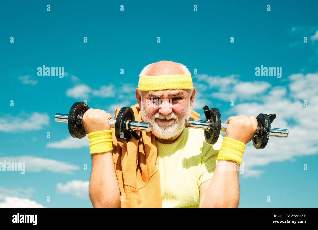 Happy Senior man exercising with lifting dumbbell outdoor. Grandfather ...