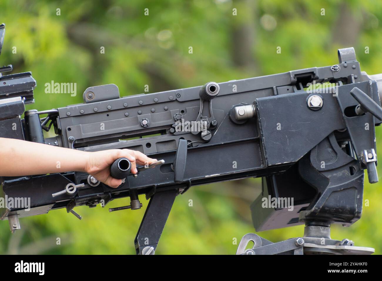 A child aims a machine gun at a military equipment exhibition. Children ...