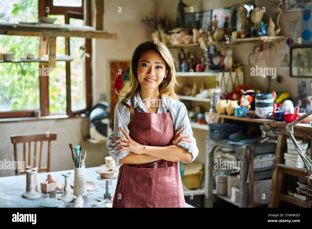 Pretty female artist smiling and posing at creative workshop with her ...