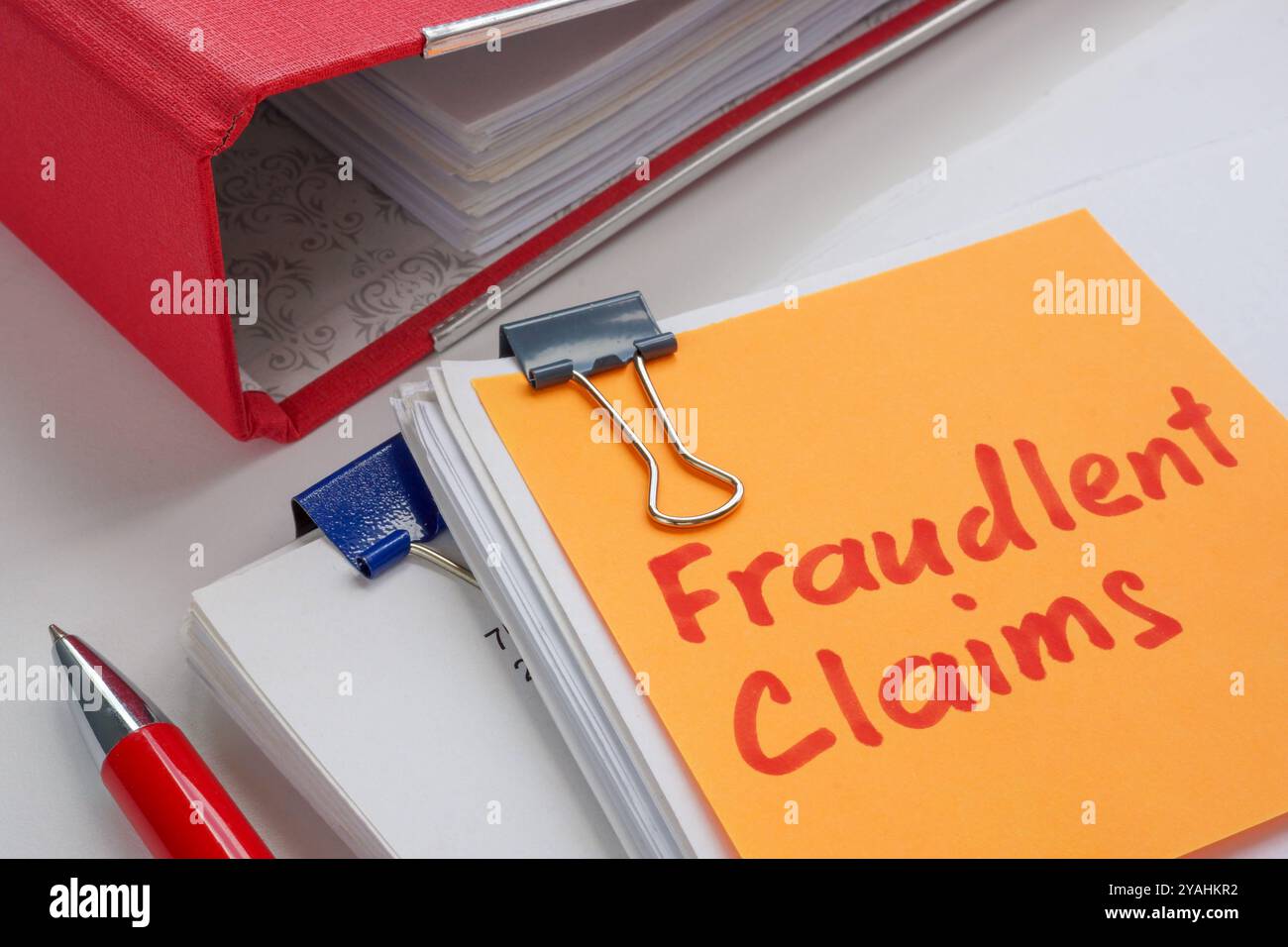 A stack of papers labeled fraudulent claims. Insurance fraud and legal ...