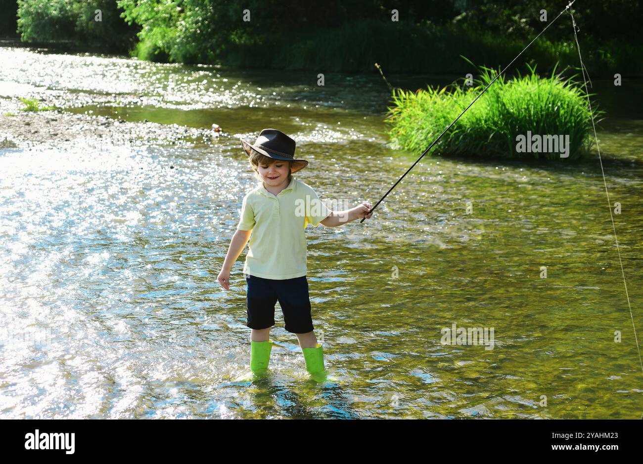 Little kid pulling fishing rod while fishing on weekend. Boy fish in ...